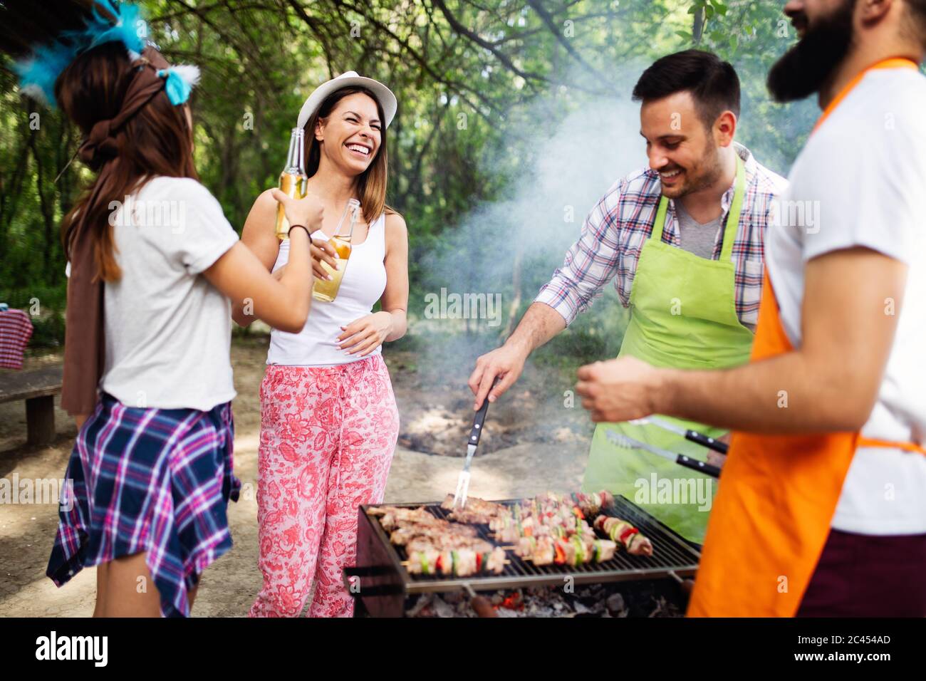 Group of happy friends having outdoor barbecue party and fun together Stock Photo - Alamy