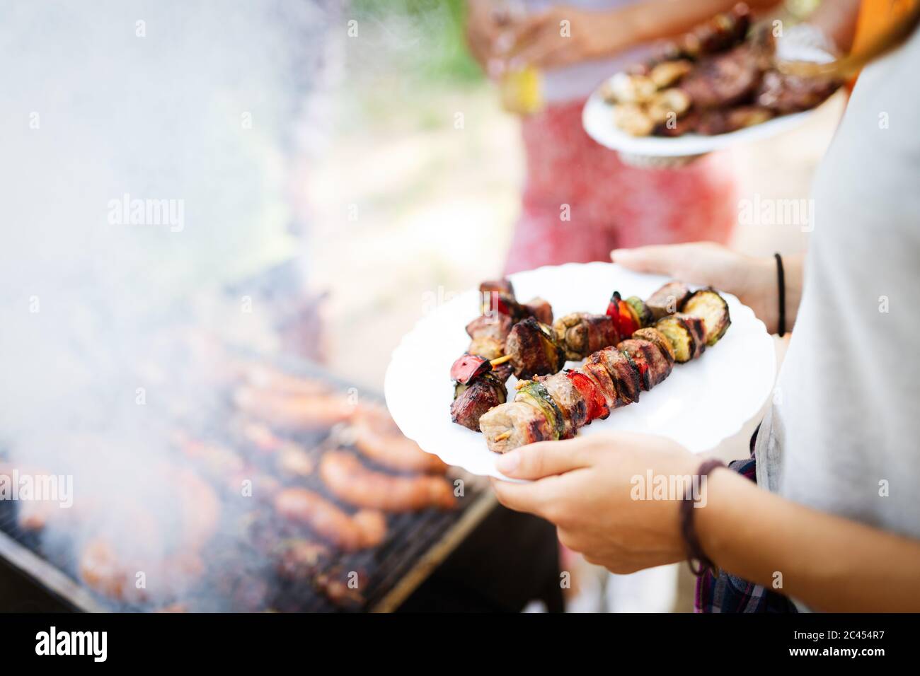 Group of happy young friends having barbecue party, outdoors Stock ...