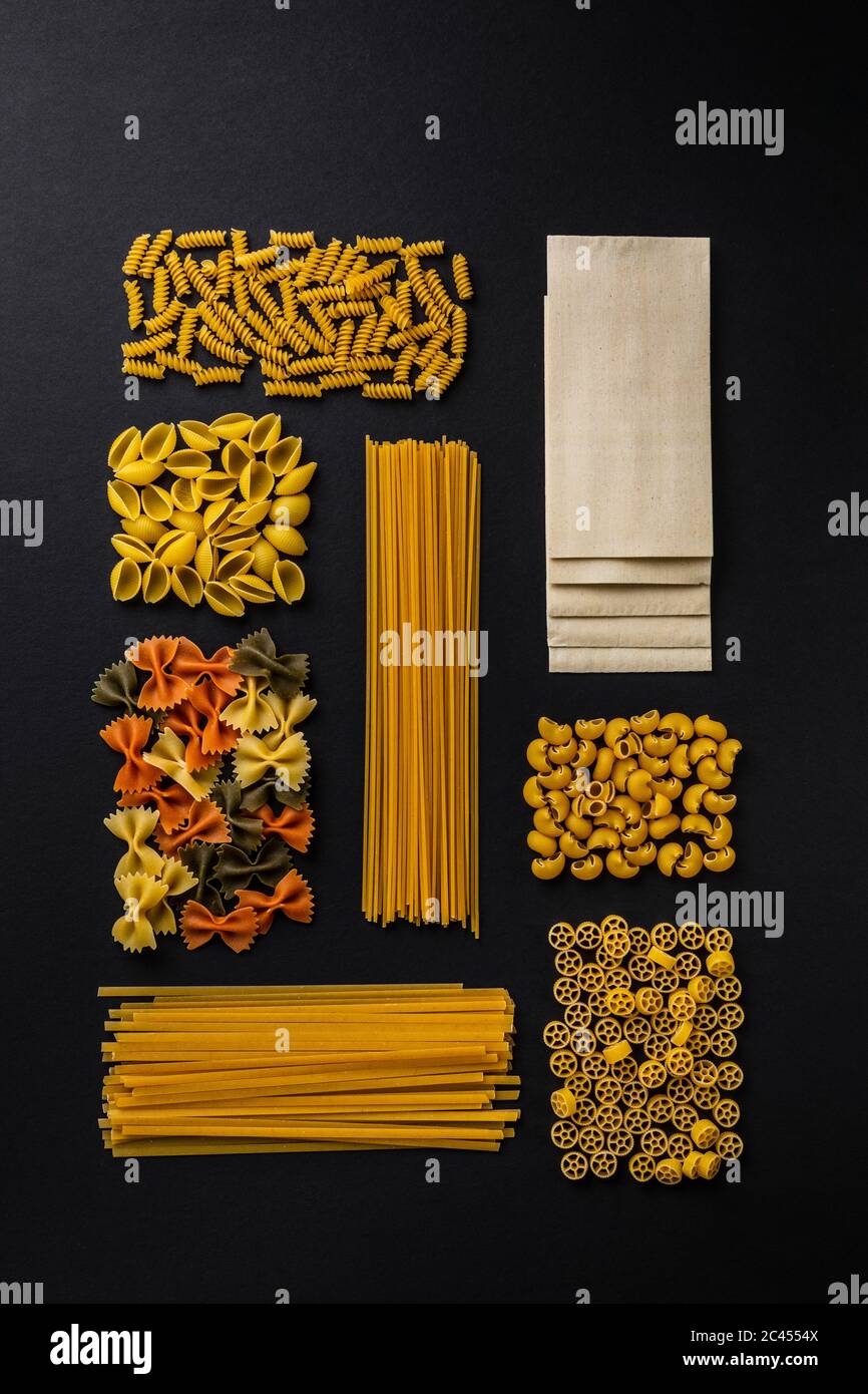 Vertical high angle shot of different shapes and kinds of pasta and ...