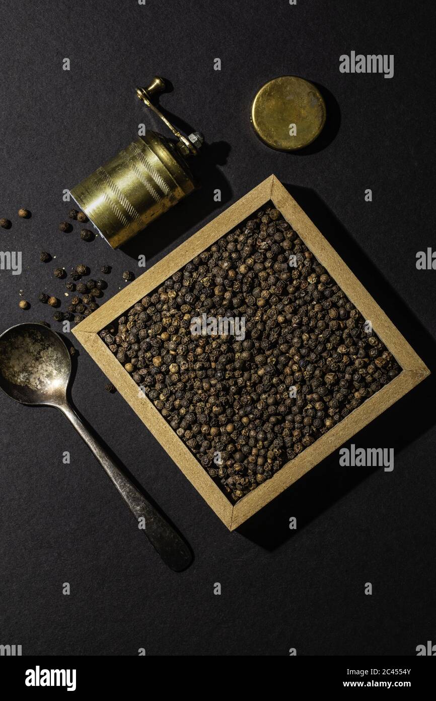 Vertical high angle shot of raw cocoa beans in a box and a grinder on a ...