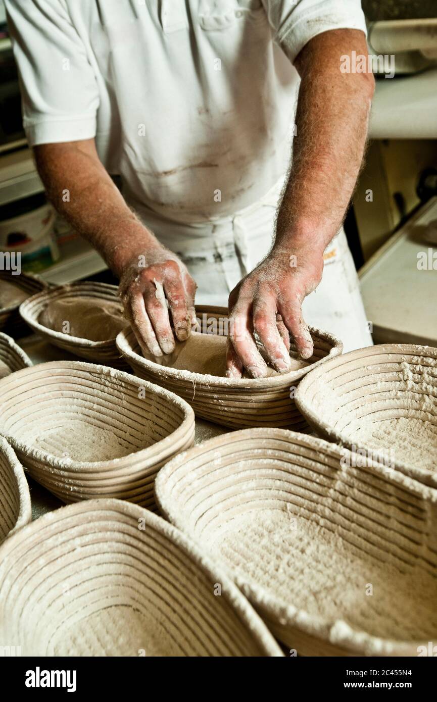 Baker in a bakery prepares bread Stock Photo - Alamy