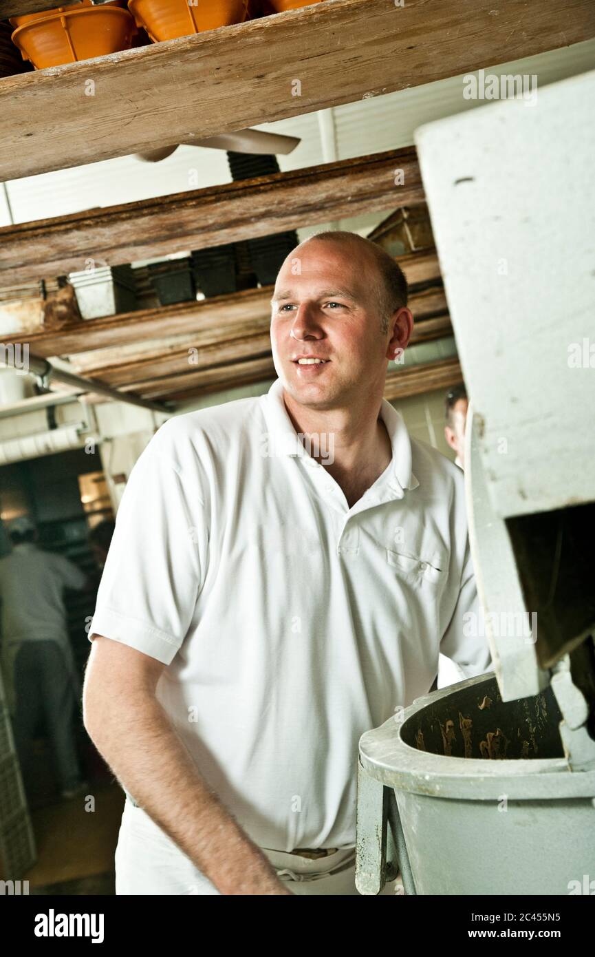 Smiling baker in a bakery Stock Photo - Alamy