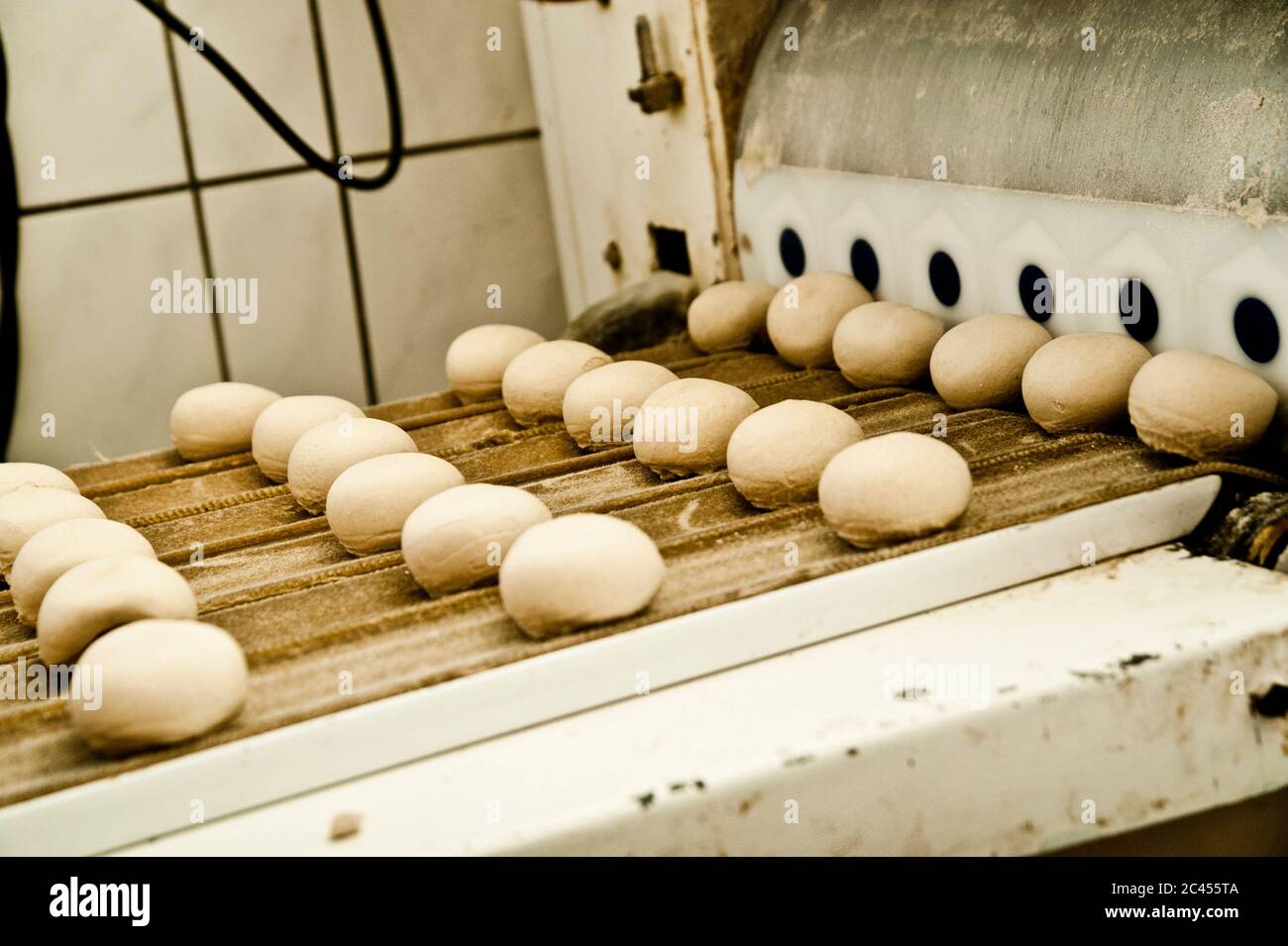 Unbaked rolls on an assembly line in a bakery Stock Photo - Alamy