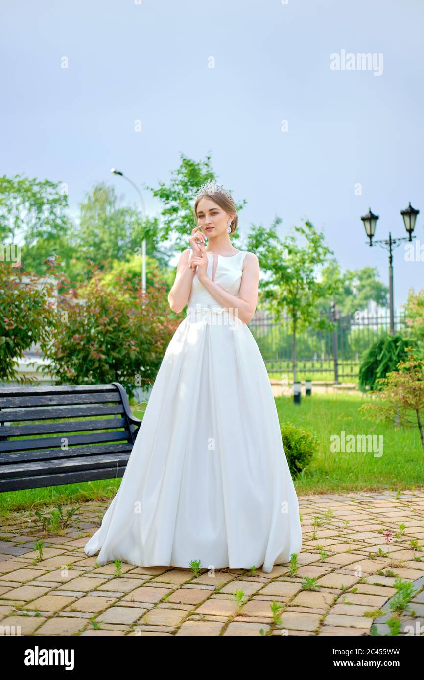 Portrait of pretty bride with coronet in hair outdoor near ceremony ...