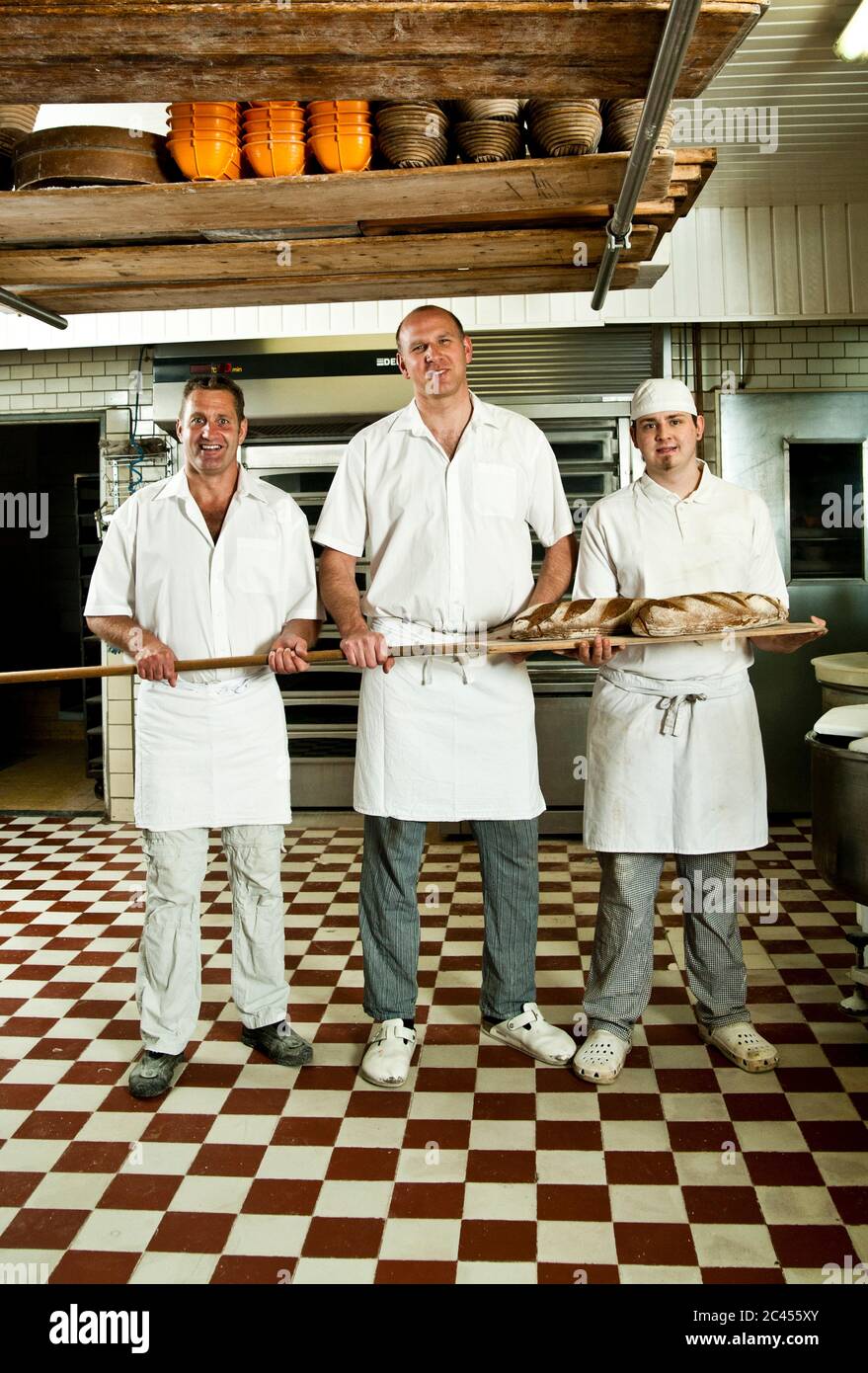 Three smiling bakers stand side by side Stock Photo - Alamy