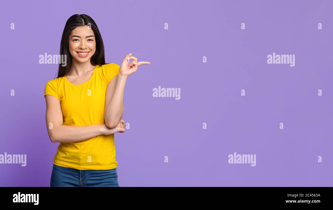 Look At This. Positive Korean Girl Pointing Finger Aside At Copy Space ...