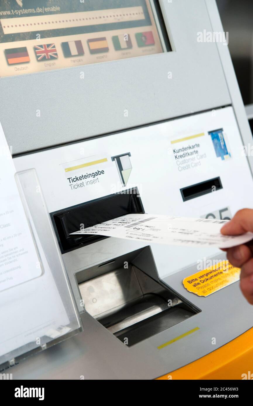 Hand with flight ticket at an airport check-in machine Stock Photo - Alamy