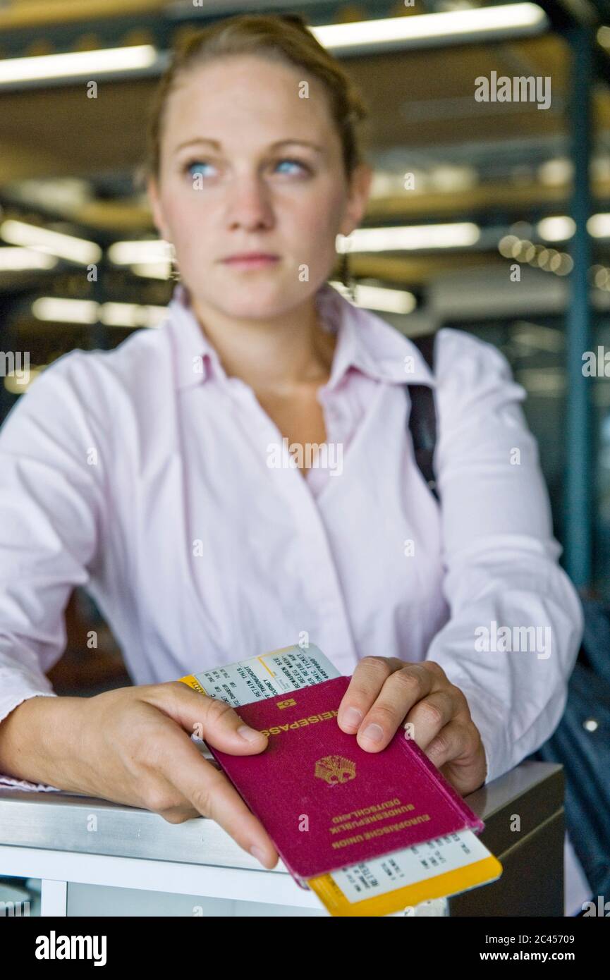 Young woman with passport and plane ticket at check in Stock Photo - Alamy