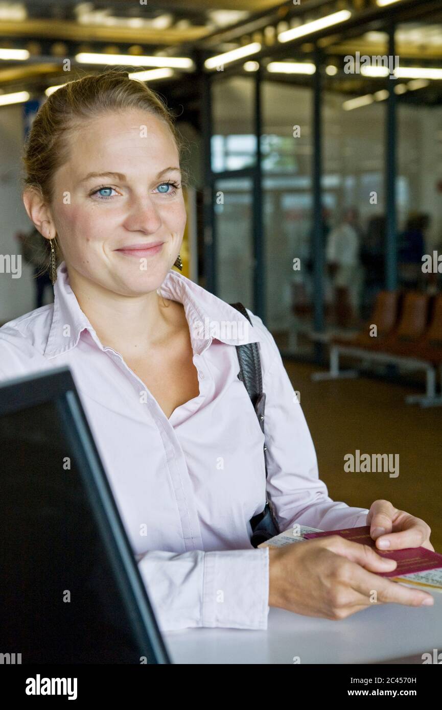 Young woman with passport and plane ticket at check in Stock Photo - Alamy
