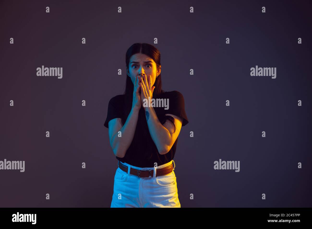 Shocked, scared. Caucasian young woman's portrait on dark studio ...