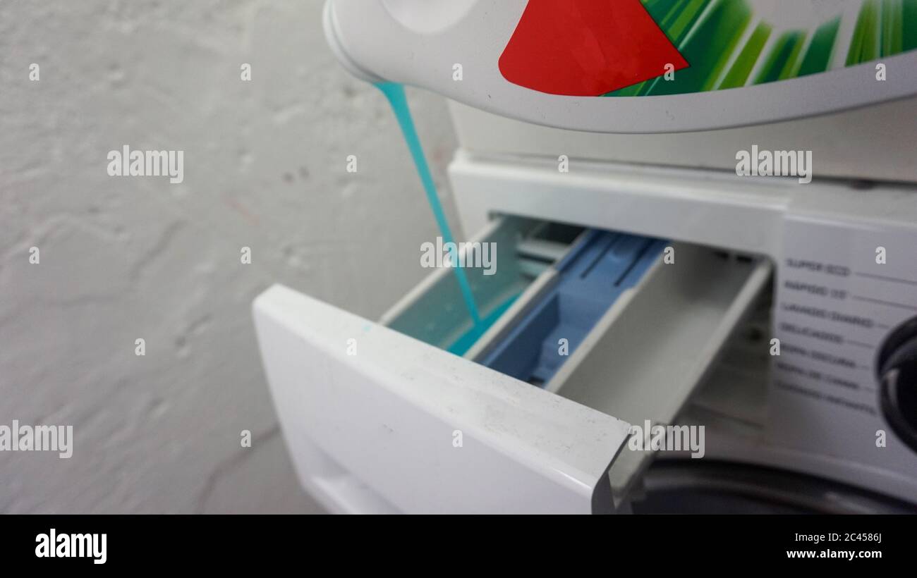 Liquid laundry detergent pouring into the washing machine Stock Photo ...
