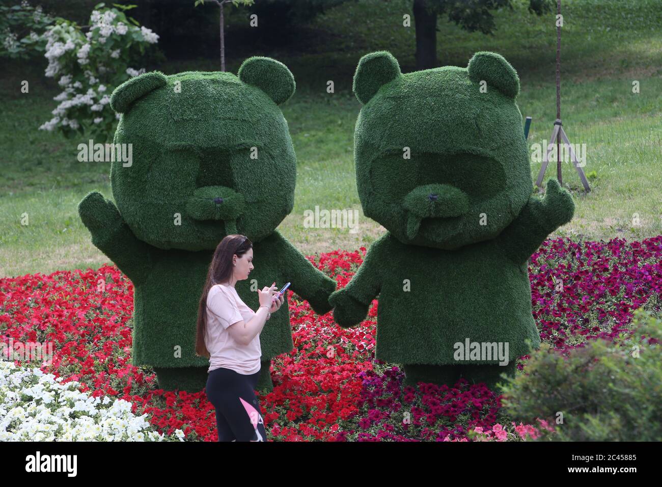Kiev, Ukraine. 23rd June, 2020. A woman passes by a bear topiaries at ...