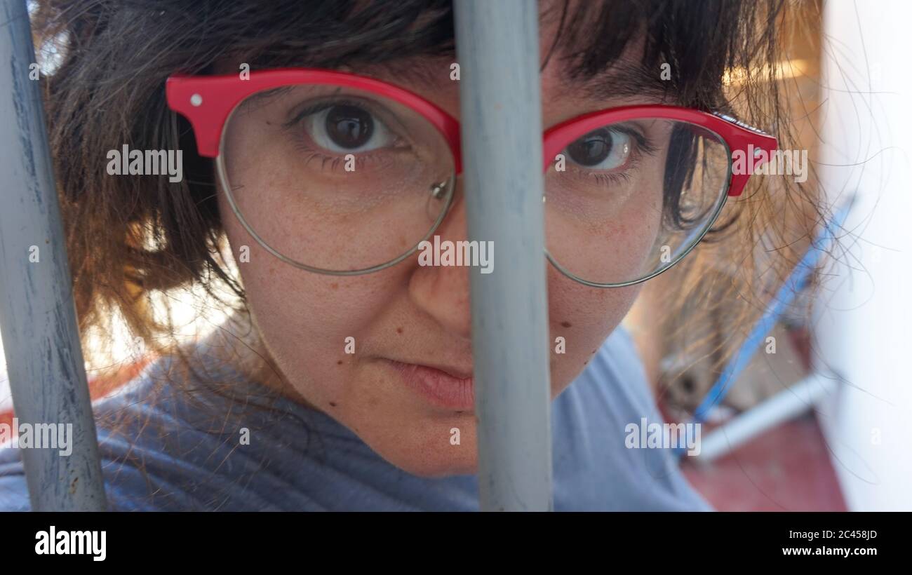 Woman wearing red glasses behind the lattice Stock Photo - Alamy