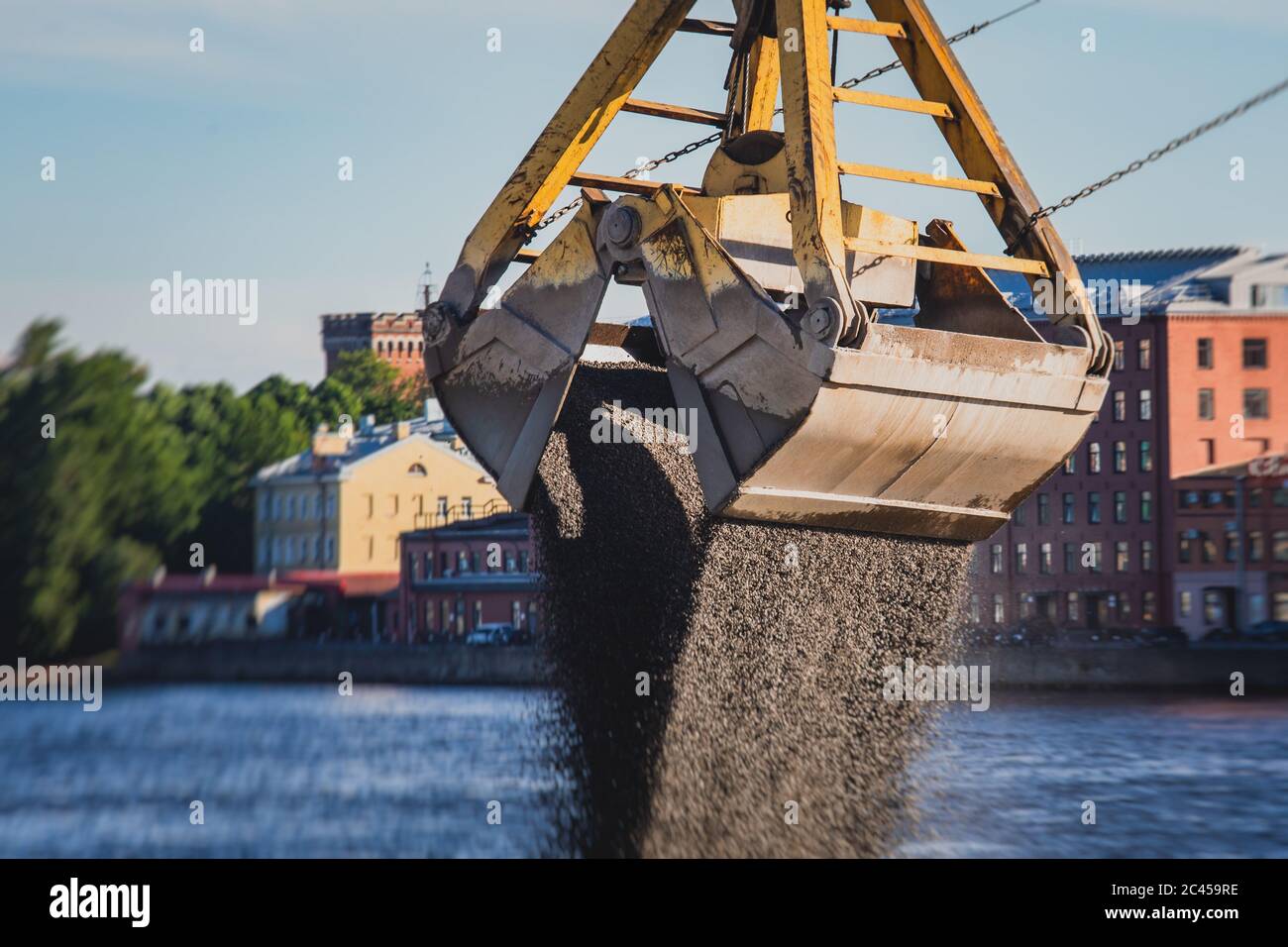 Bulk-handling crane unloading sand, road metal and gravel from cargo ...