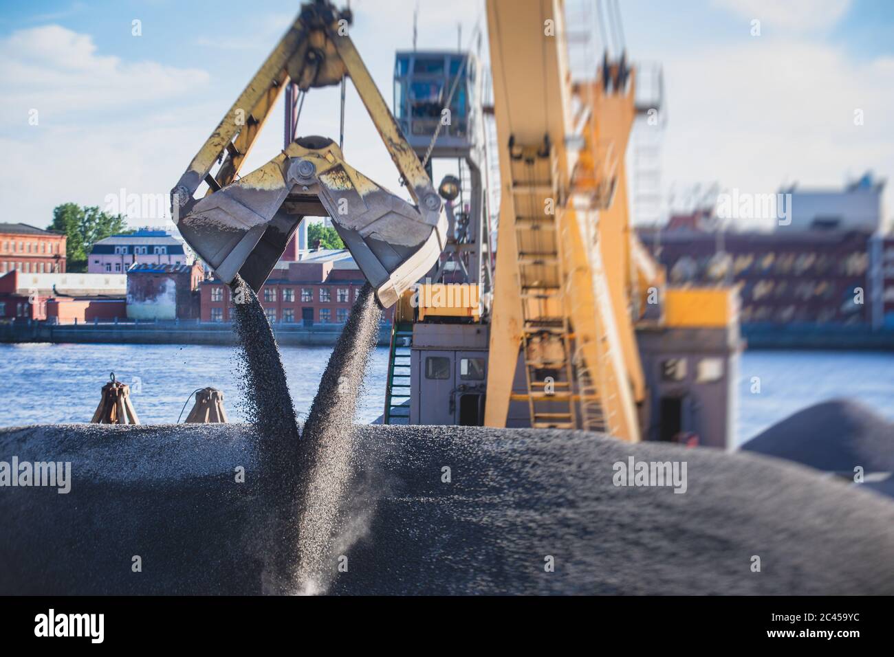 Bulk-handling crane unloading sand, road metal and gravel from cargo ...