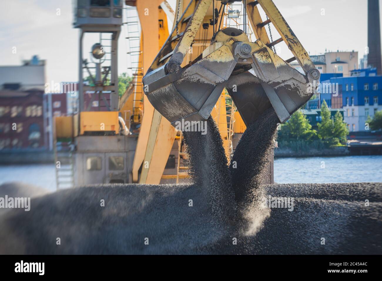 Bulk-handling crane unloading sand, road metal and gravel from cargo ...