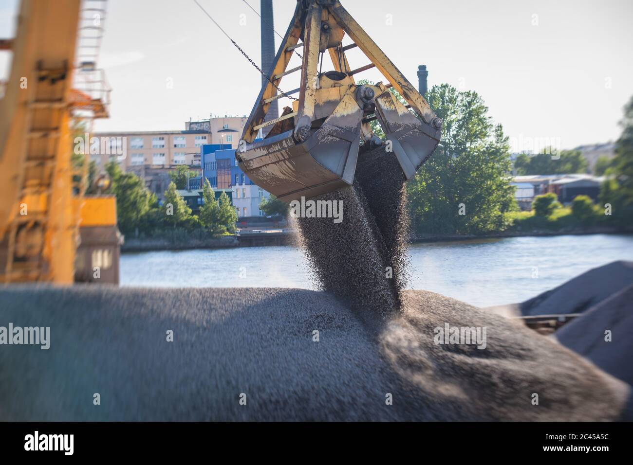 Bulk-handling crane unloading sand, road metal and gravel from cargo ...