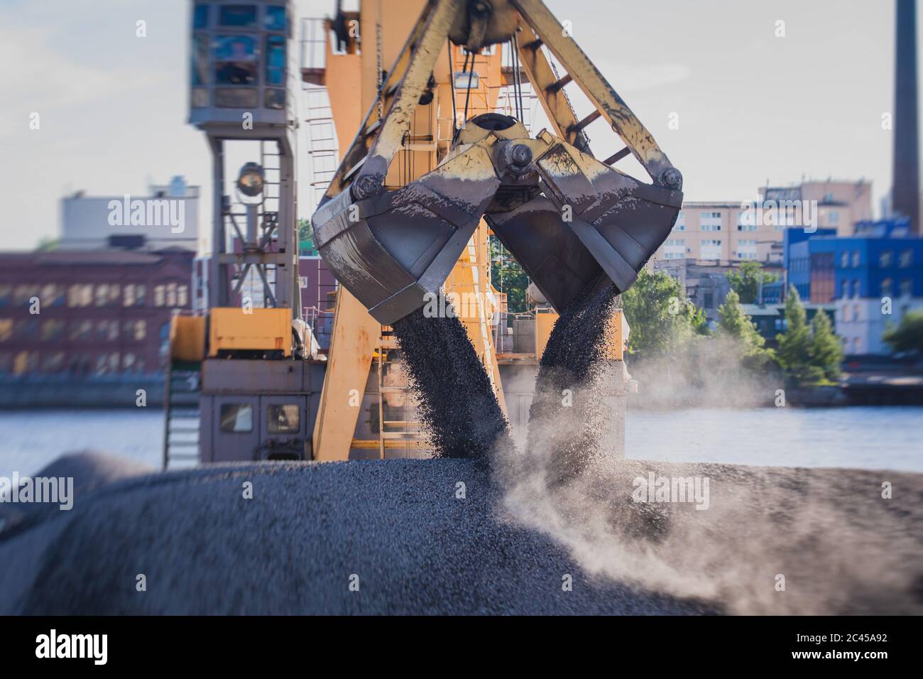 Bulk-handling crane unloading sand, road metal and gravel from cargo ...
