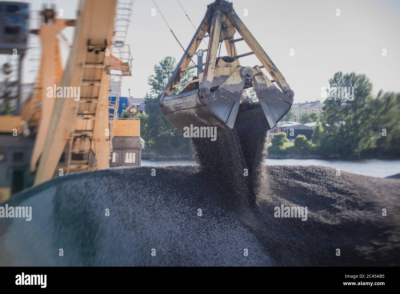 Bulk-handling crane unloading sand, road metal and gravel from cargo ...