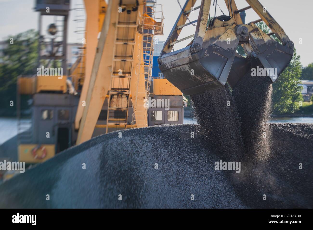 Bulk-handling crane unloading sand, road metal and gravel from cargo ...