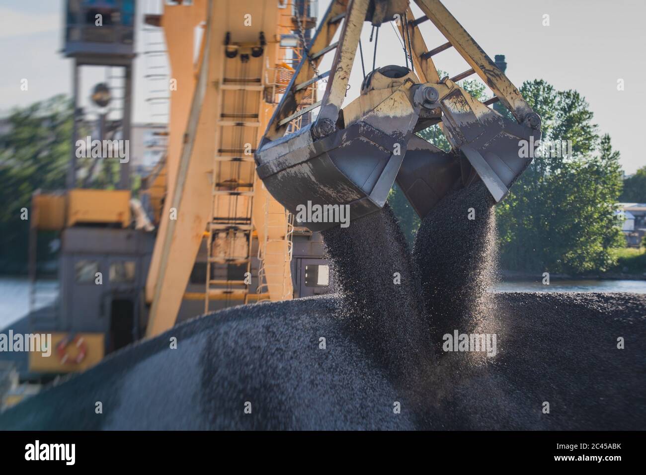 Bulk-handling crane unloading sand, road metal and gravel from cargo ...