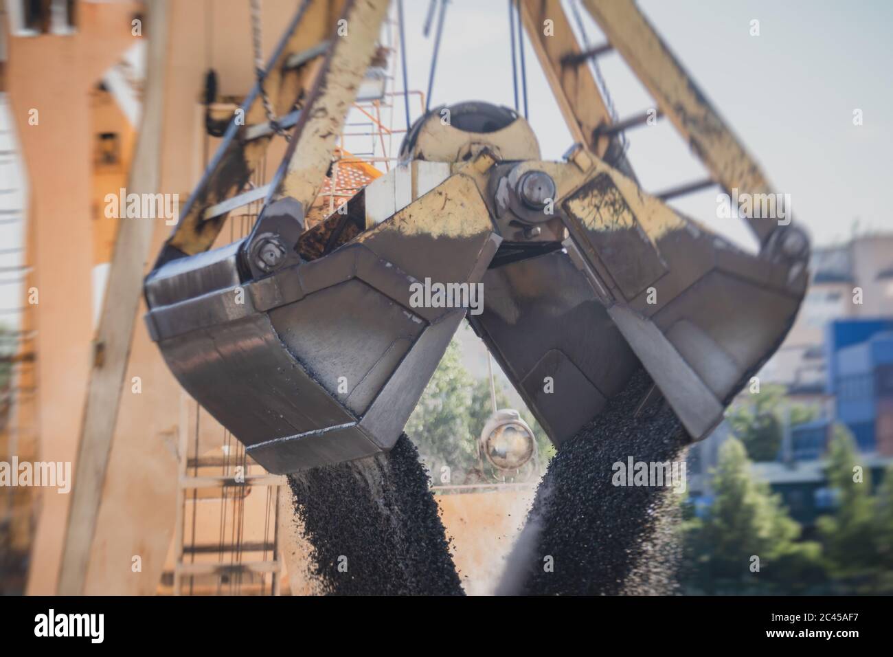 Bulk-handling crane unloading sand, road metal and gravel from cargo ...