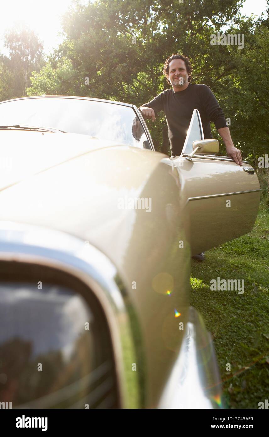 Man is standing in front of a classic car Stock Photo - Alamy
