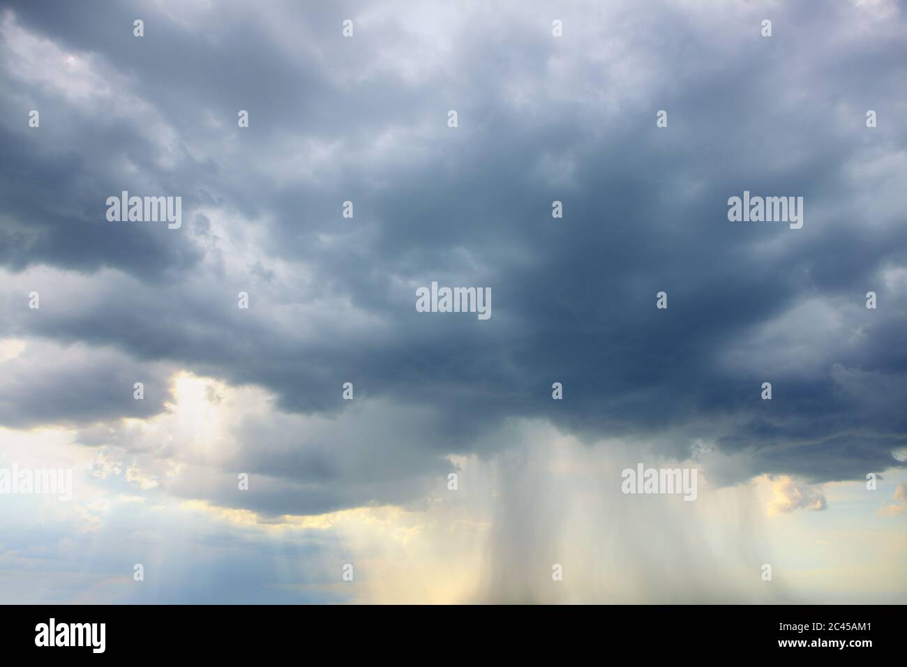 Torrents of rain from the clouds . Nature before storm . Sun rays ...