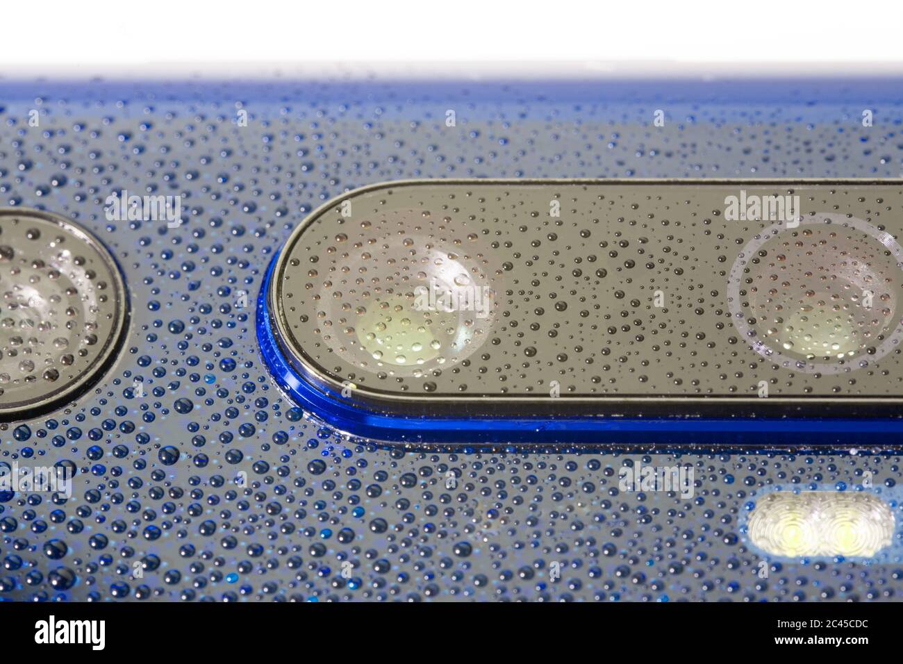 blue phone camera lens covered with small water drops - close-up with ...