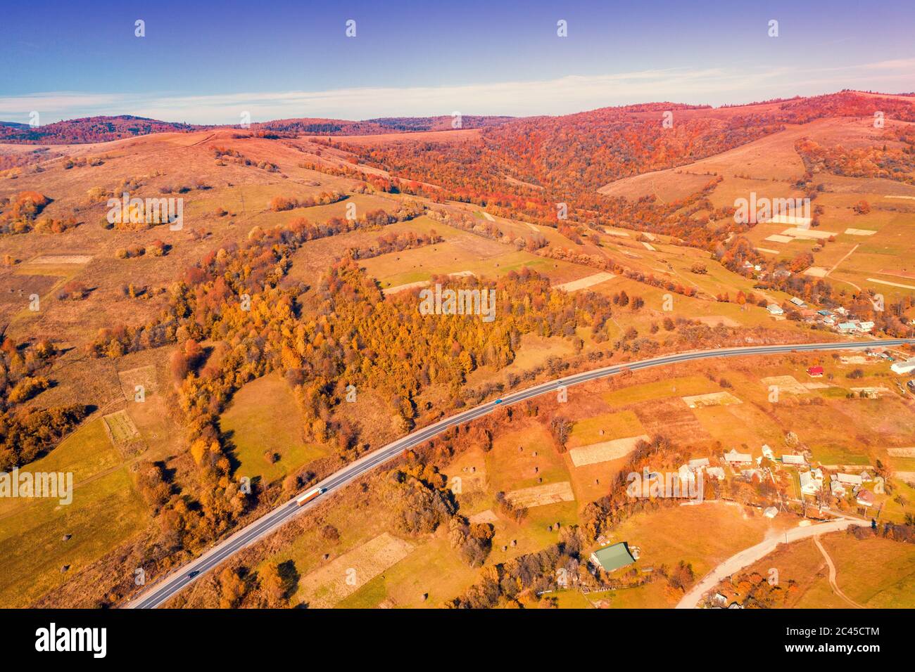 Panoramic aerial view of the mountain highway and village in autumn ...
