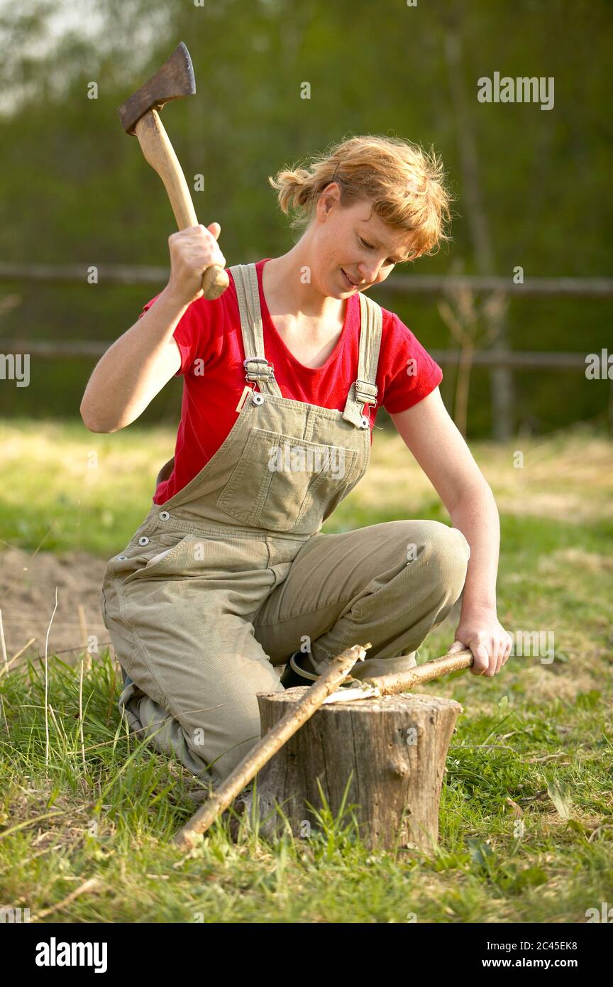 Woman chops wood Stock Photo - Alamy