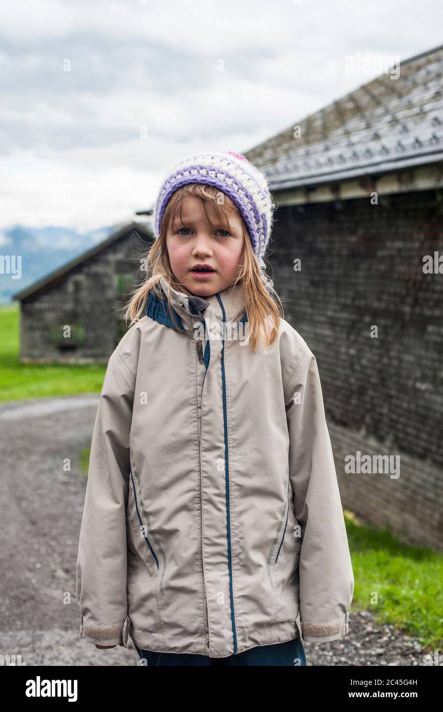 Girl stands outdoors with wool hat and rain jacket Stock Photo - Alamy