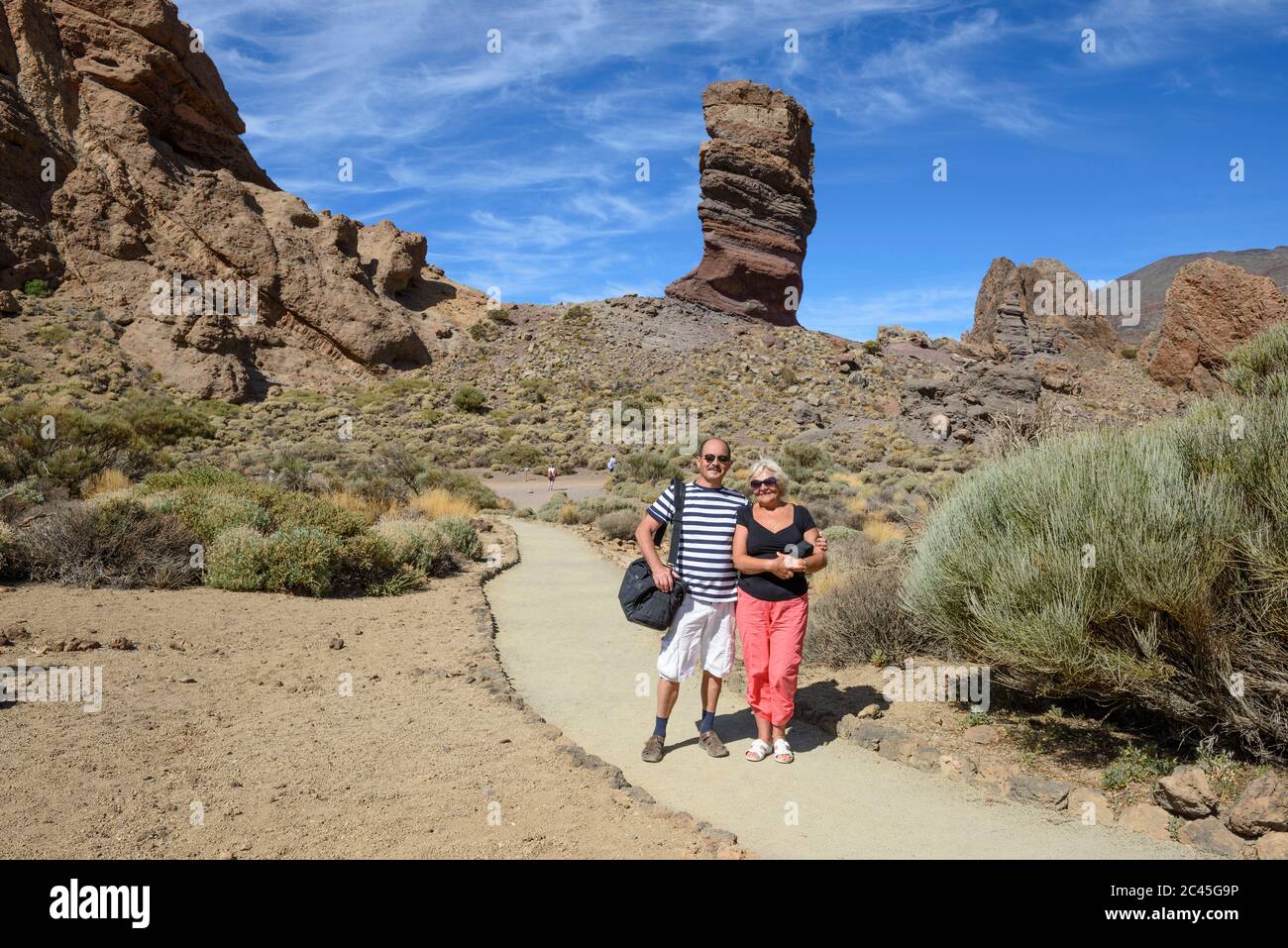 Aged couple are posing on trail near Garcia Rocks with Cinchado rock on ...