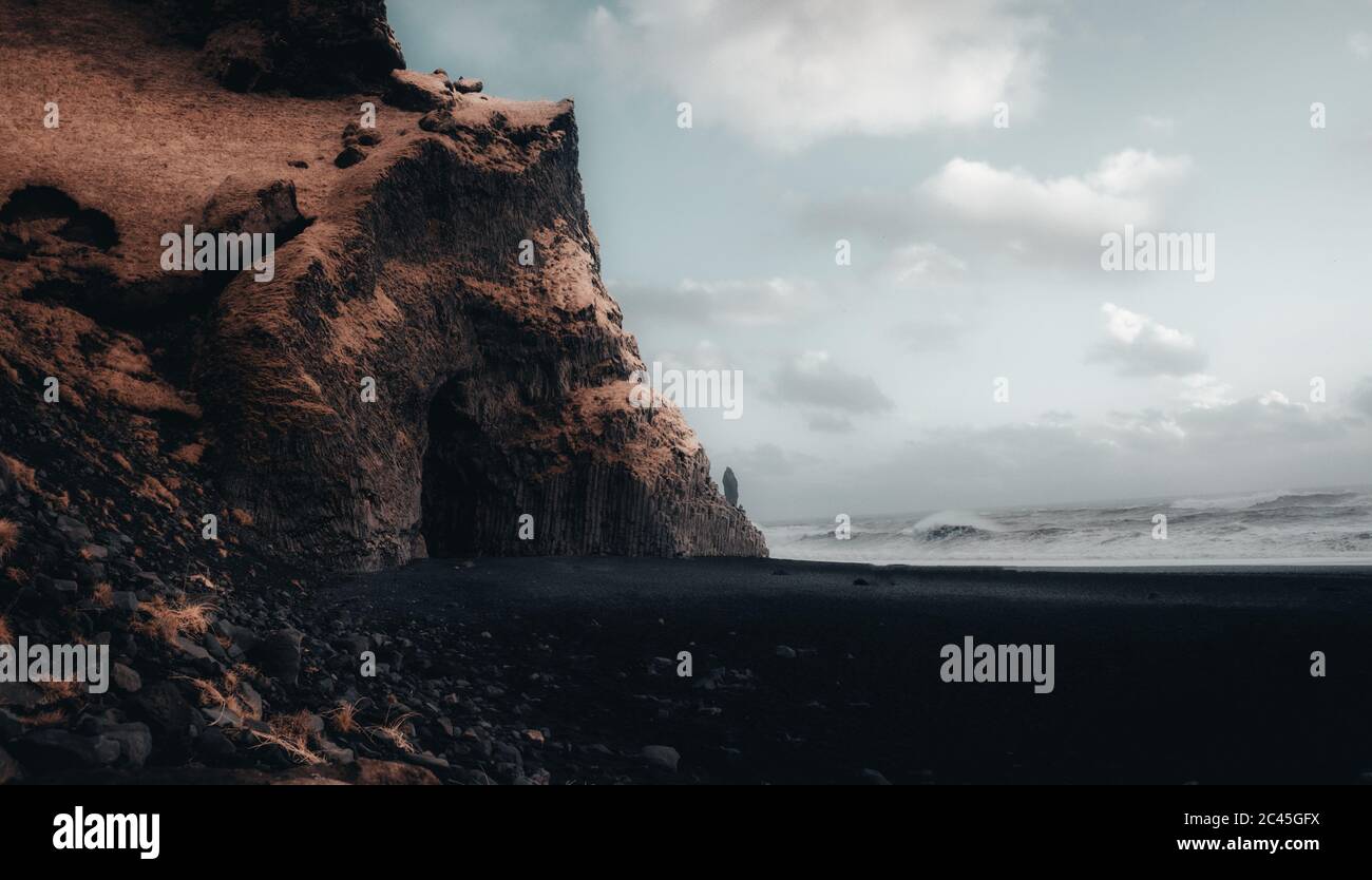 Rocks on the body of the ocean on a gloomy day in Iceland Stock Photo ...