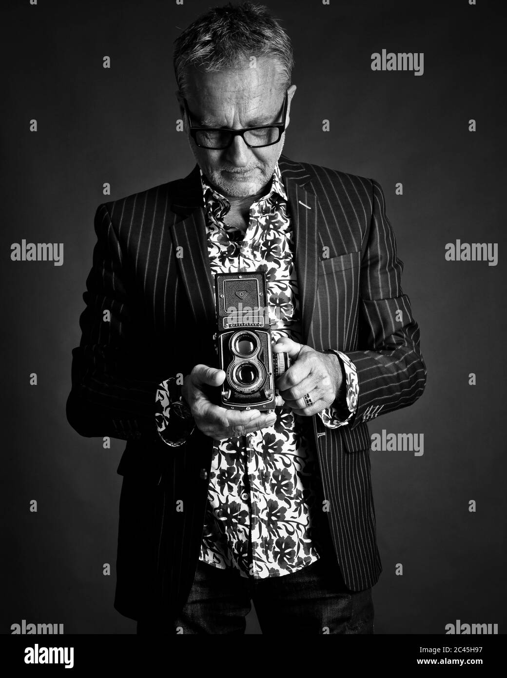 Photographer holds an old-fashioned camera Stock Photo - Alamy
