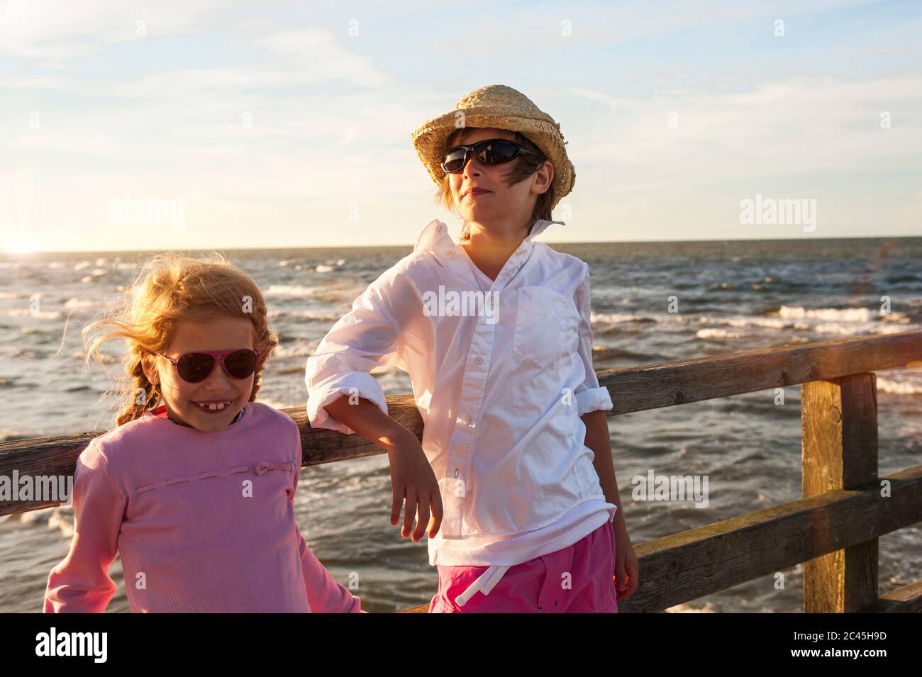 Smiling boy and girl stand on a jetty Stock Photo - Alamy