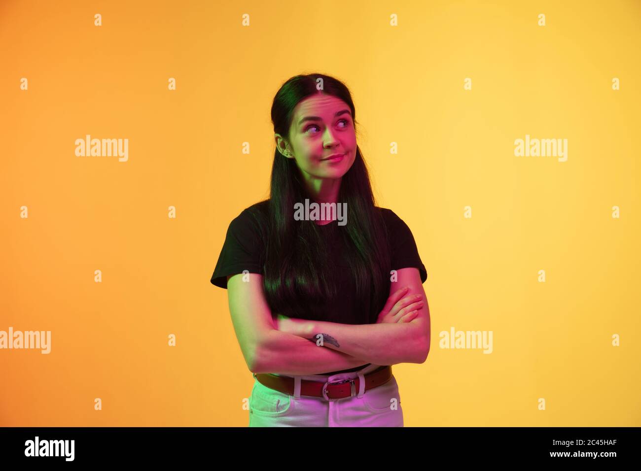 Uncertainty, doubts. Caucasian young woman's portrait on yellow studio ...