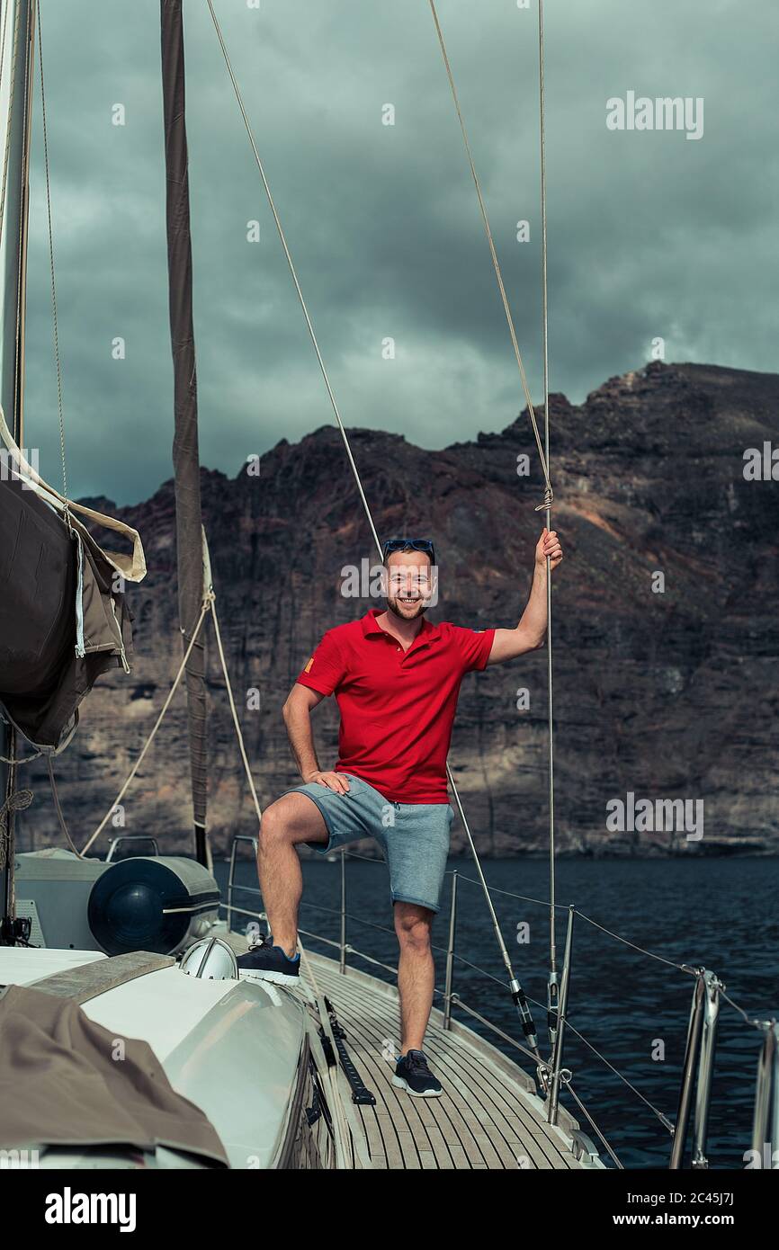 Portrait of smiling man standing aboard a sailing yacht Stock Photo - Alamy