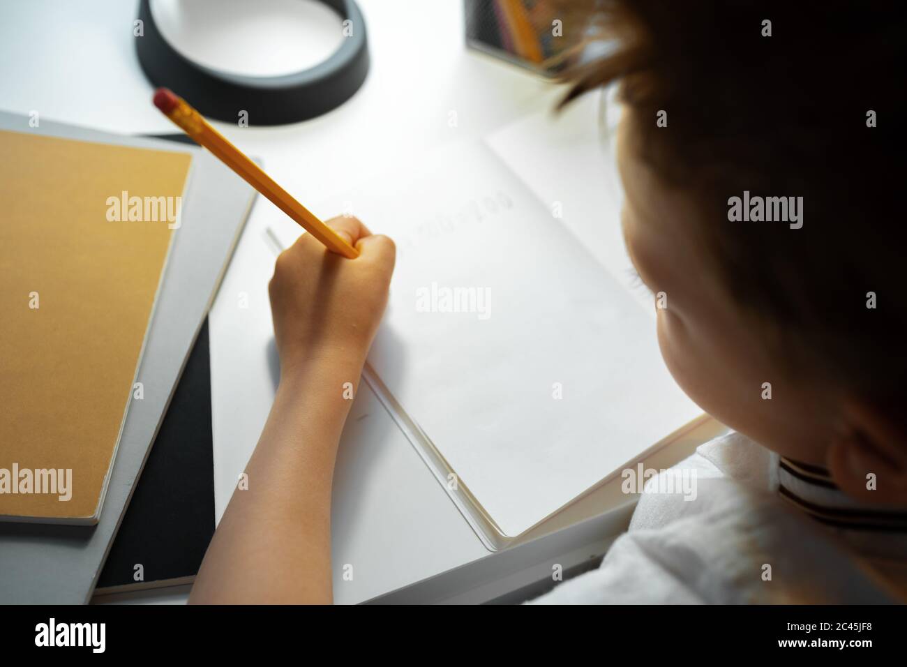 Little boy writing something in his notebook Stock Photo - Alamy