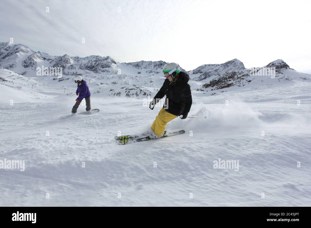 Snowboarder and skier side by side in the Stubai Valley, Tyrol, Austria ...