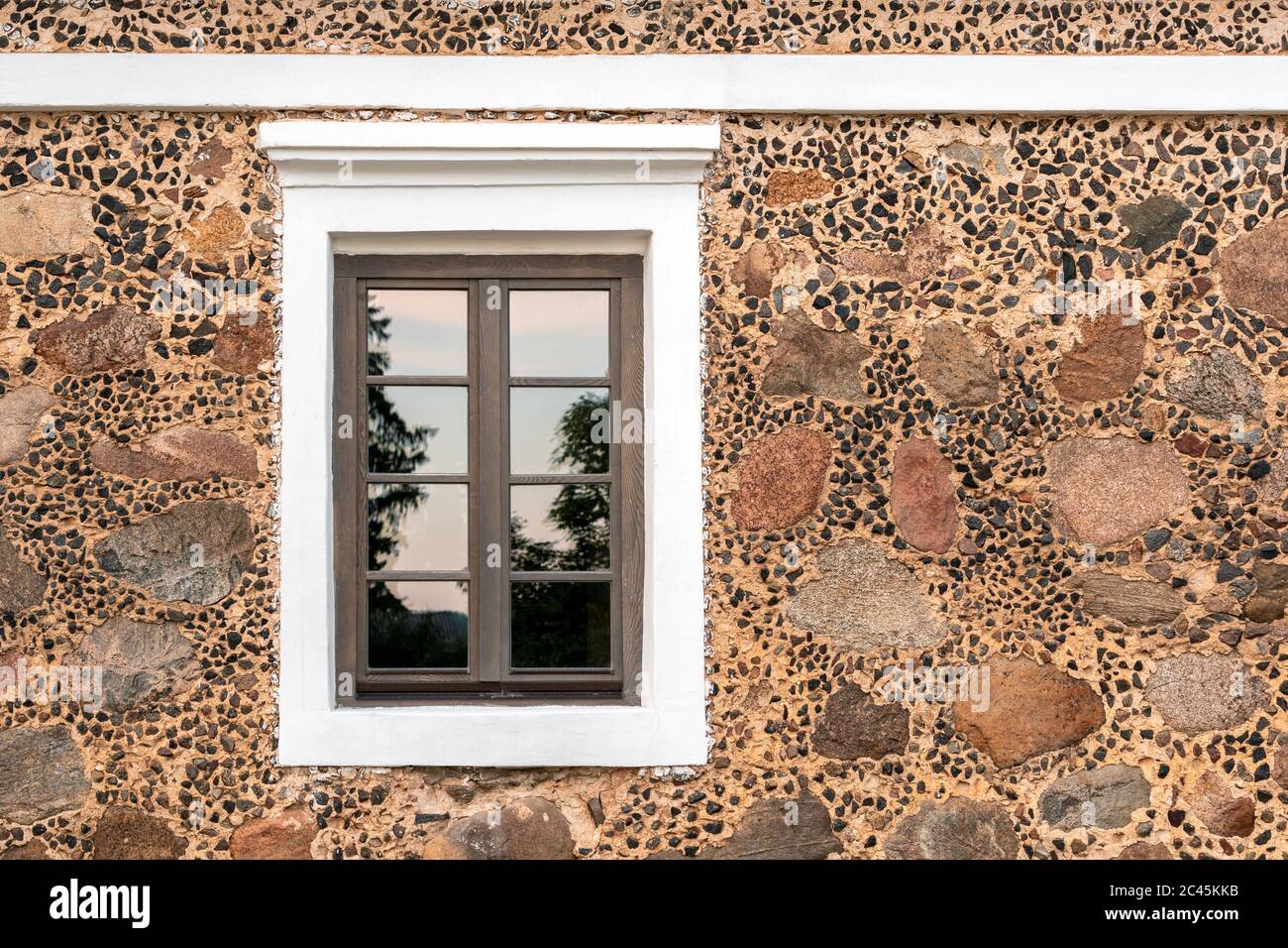Window surrounded by a wall of rocks and stones Stock Photo - Alamy