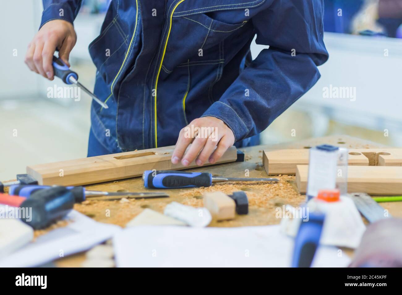 Professional man carpenter using chisel to carve wood on rough ...