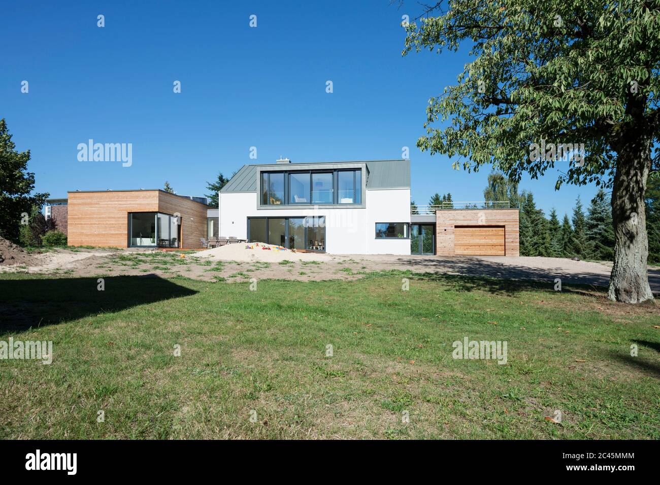 Residential house with wooden garage under a blue sky Stock Photo - Alamy