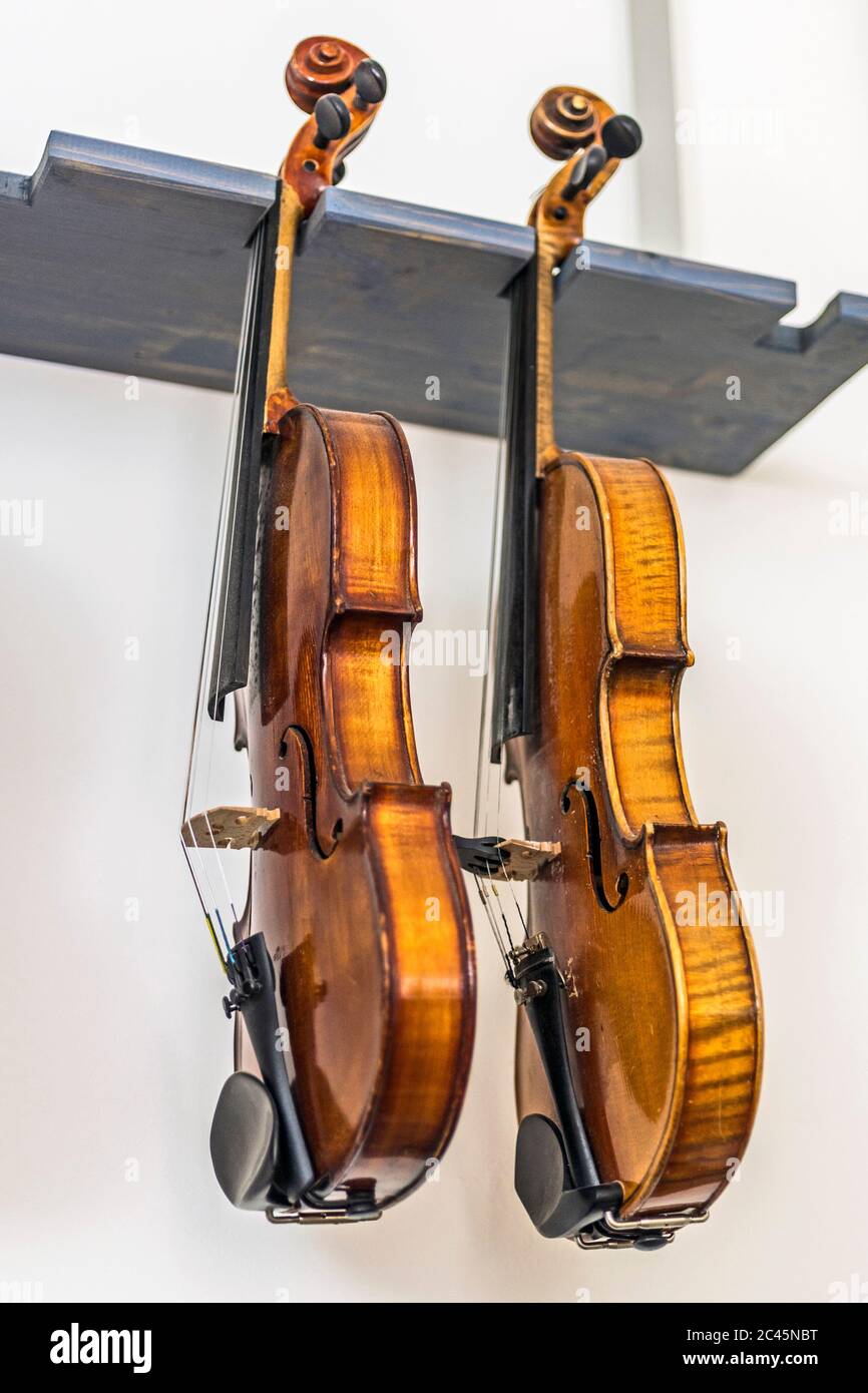 Violins hang in the workshop of a violin maker Stock Photo - Alamy