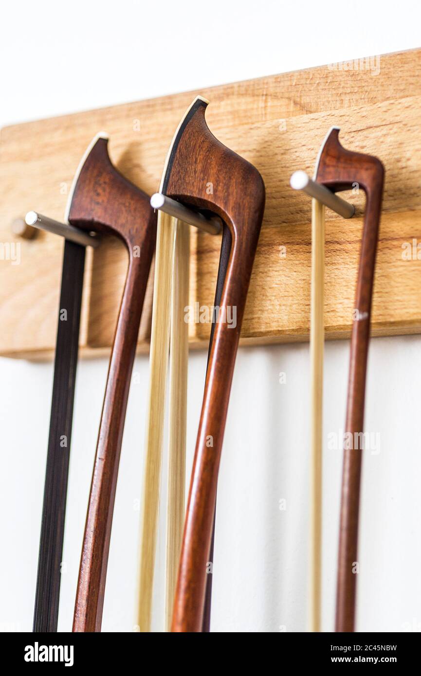 Violin bows hang in the workshop of a violin maker Stock Photo - Alamy