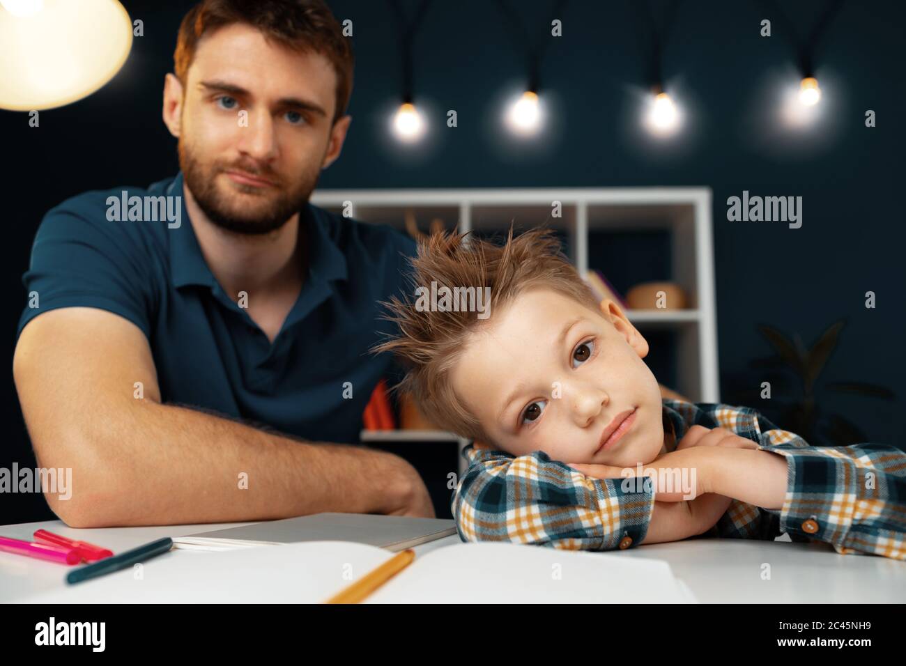 Dad and son doing school homework together Stock Photo - Alamy