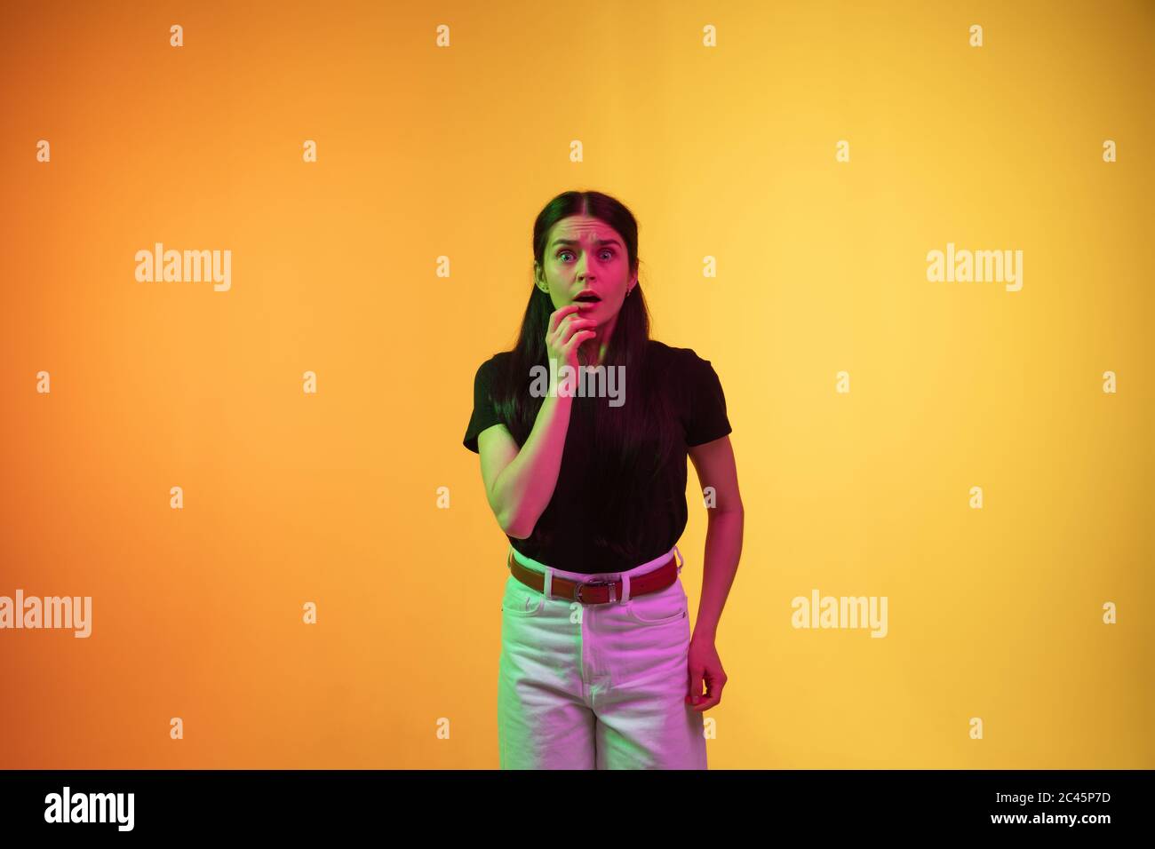 Shocked, scared. Caucasian young woman's portrait on yellow studio ...