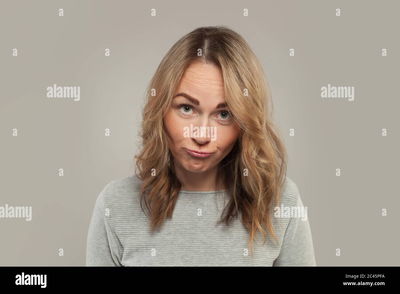 Cute woman grimacing on white background Stock Photo - Alamy