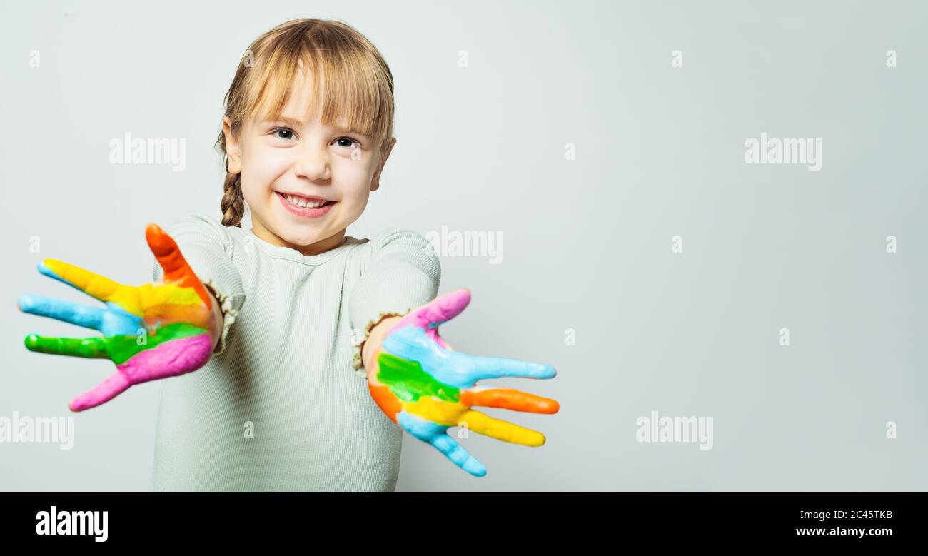 Happy girl showing her colorful painted hands. Child art school student ...