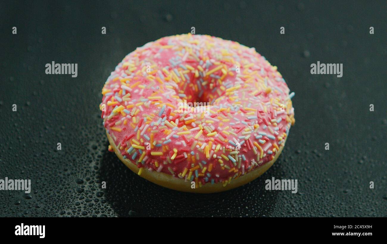 Pink donut with sprinkles Stock Photo - Alamy